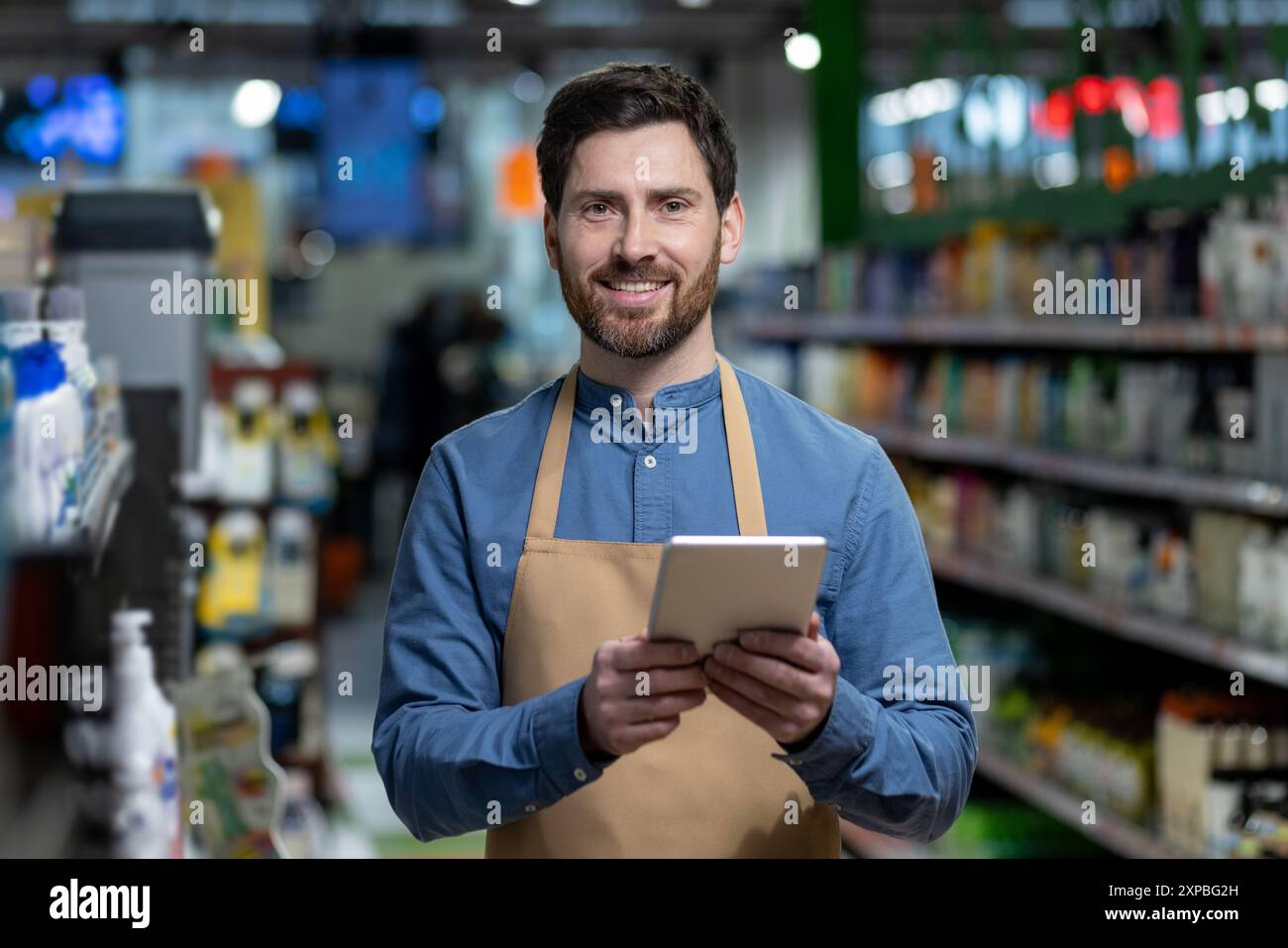 Smiling supermarket worker using digital tablet for inventory ...