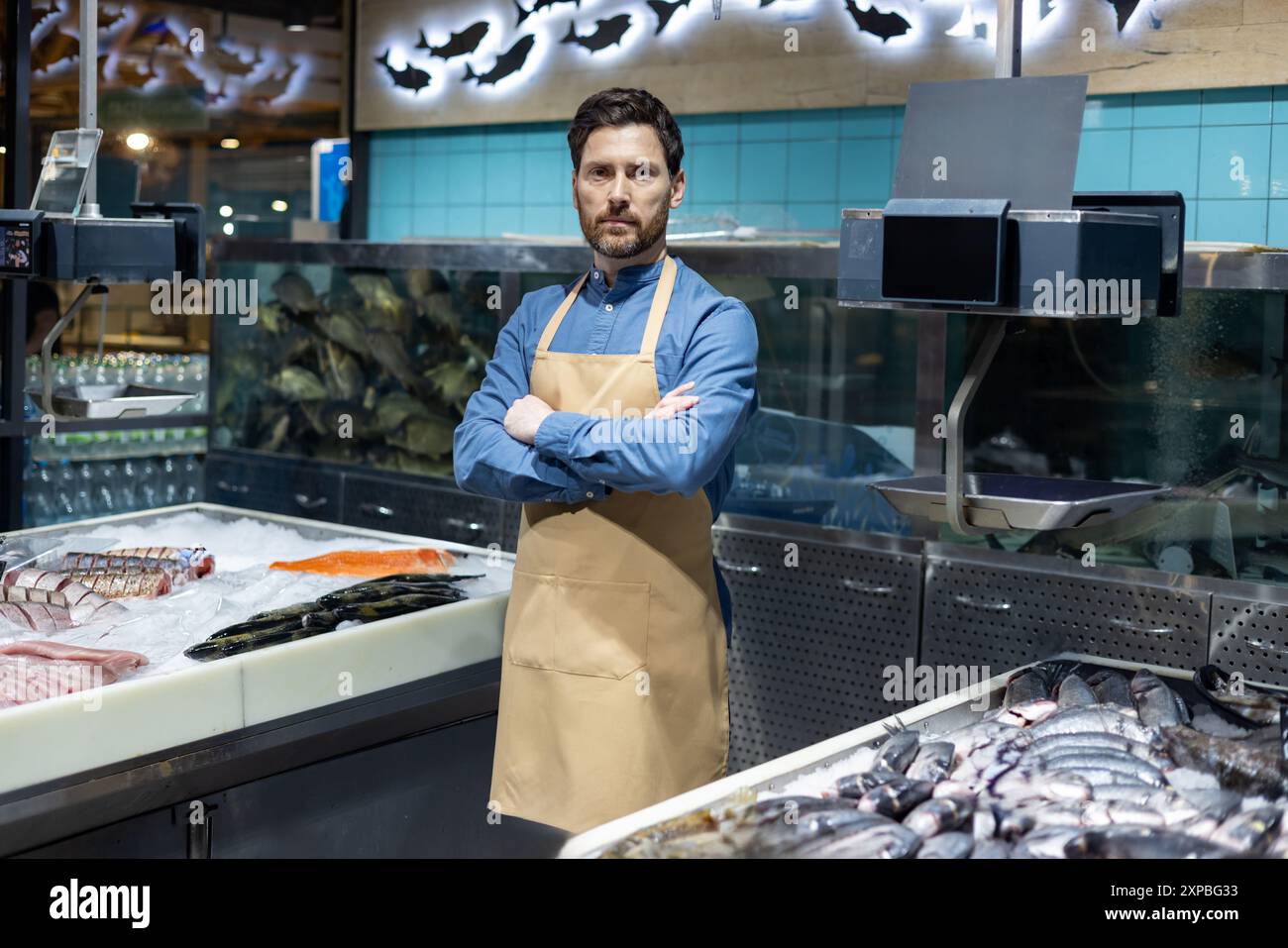 Fishmonger standing confidently with arms crossed in seafood market ...
