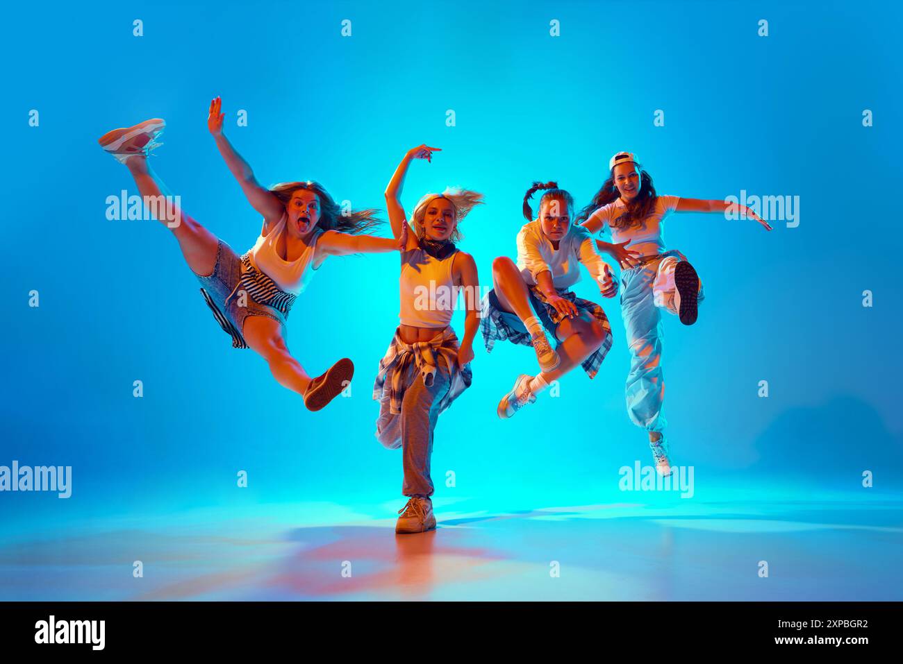 Four dancers leap into air with exuberant and dynamic poses in vibrant ...