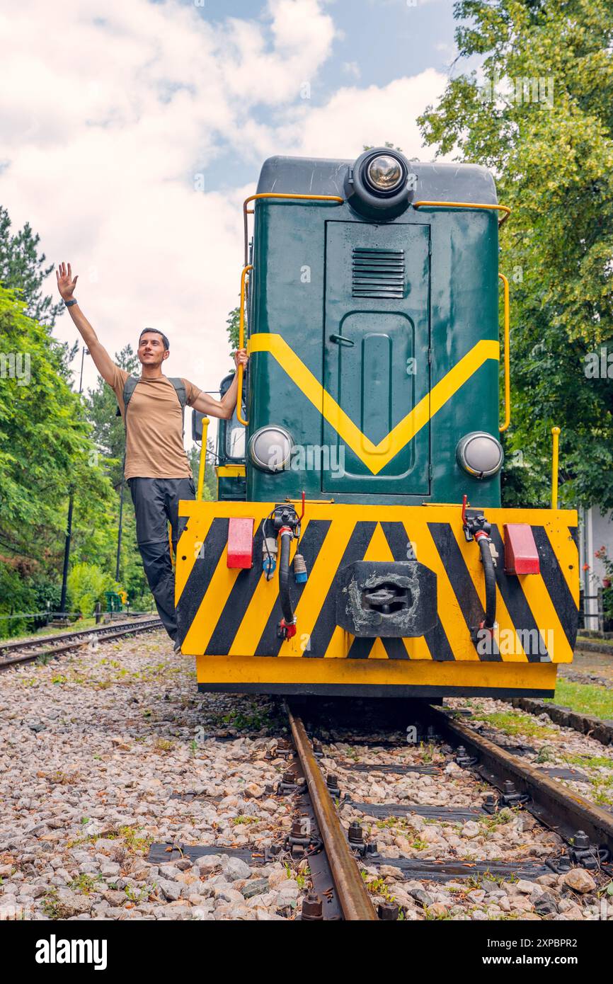 A tourist smiling as they board a vintage train at the platform, ready ...