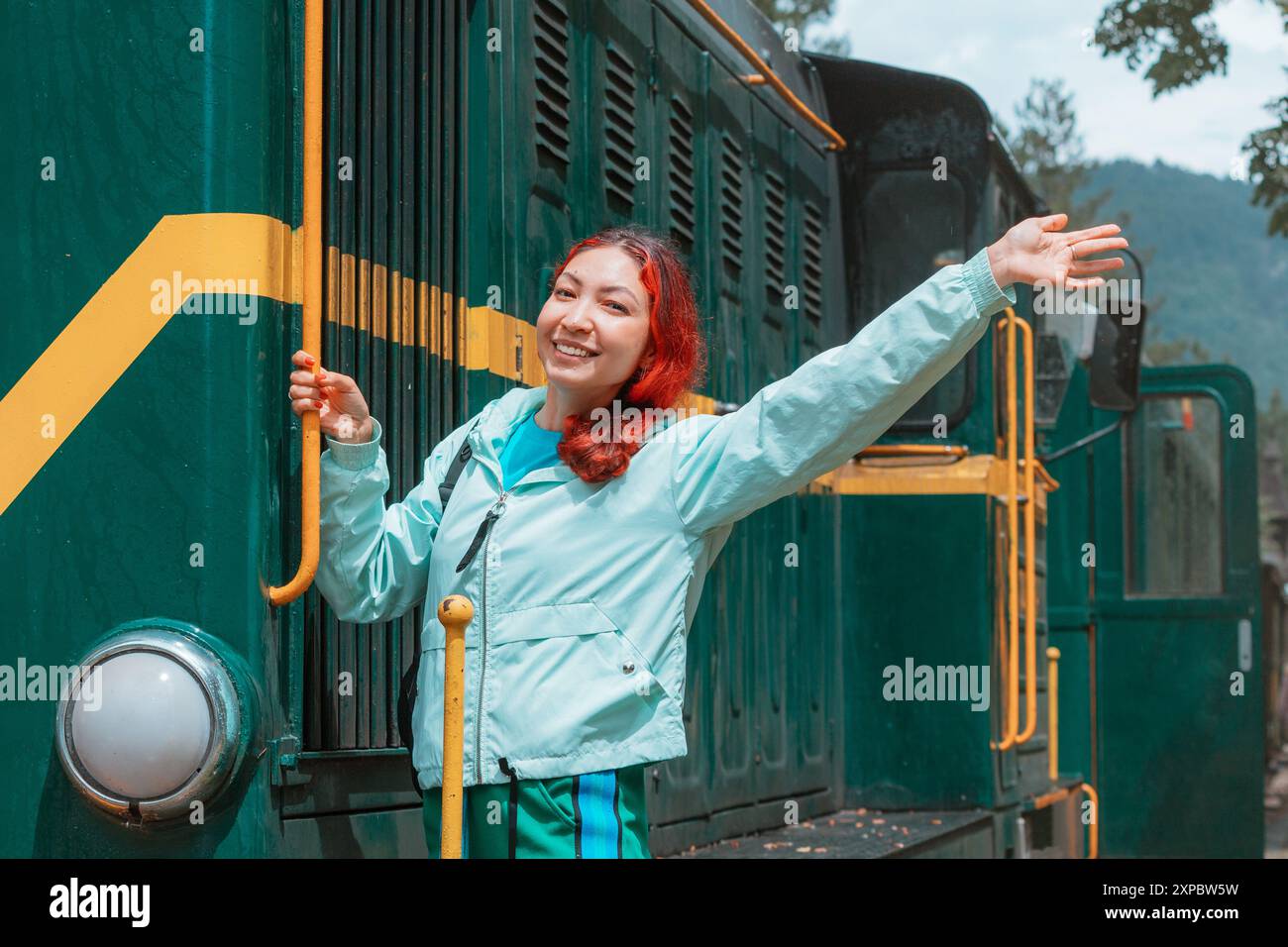 Retro train departing from station, a smiling woman tourist waving ...