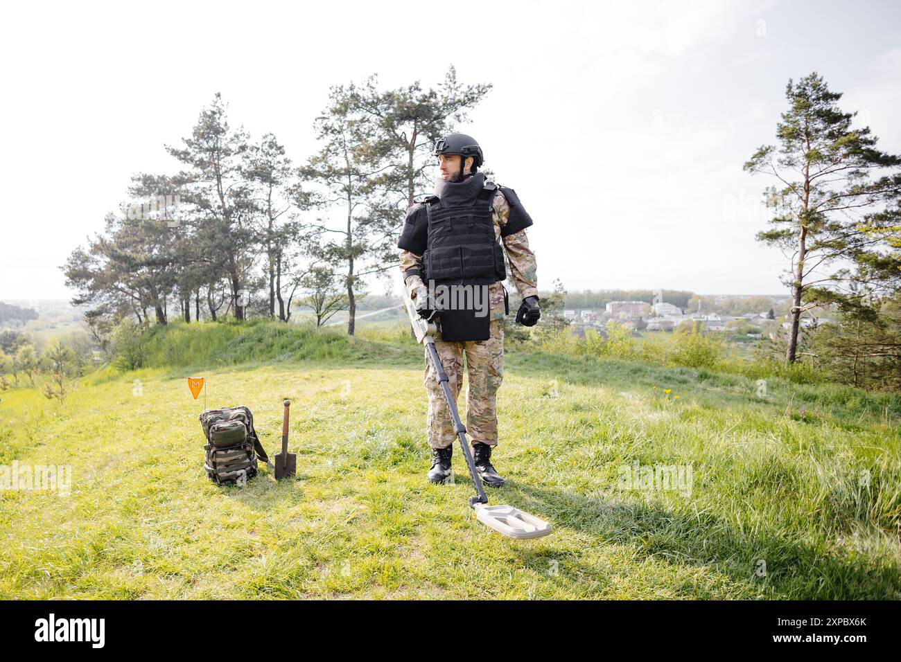 A man in a military uniform and bulletproof vest works in the forest ...