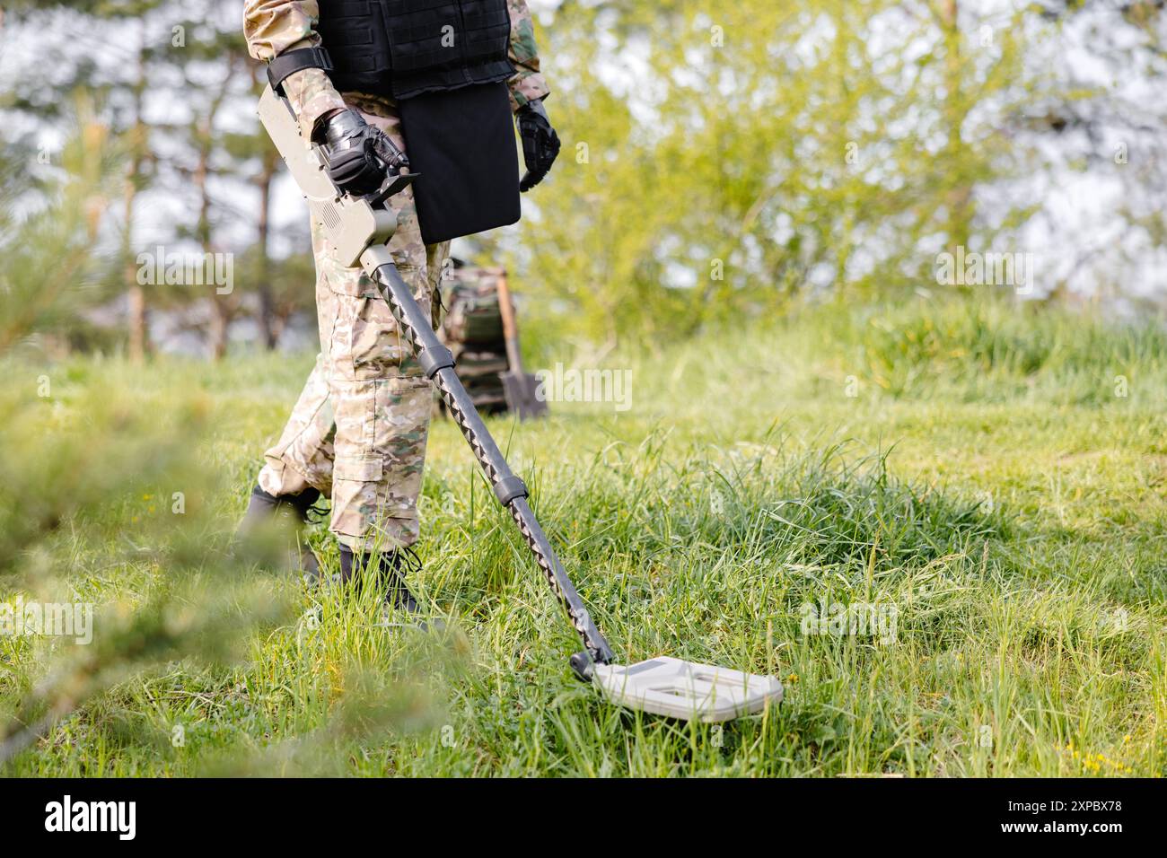 A man in a military uniform and bulletproof vest works in the forest ...