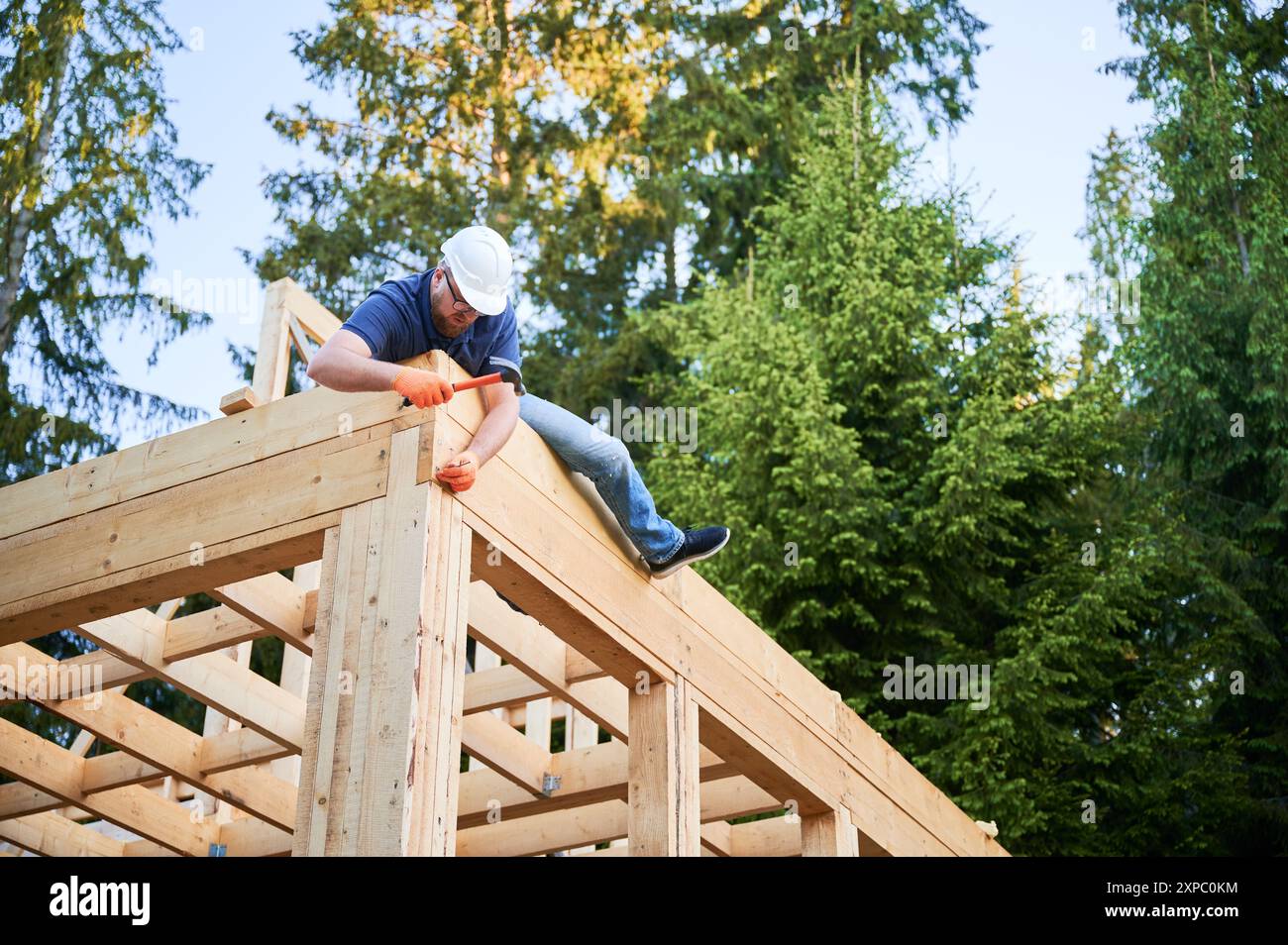 Woodworker constructing wooden, two-story frame-built house near the ...