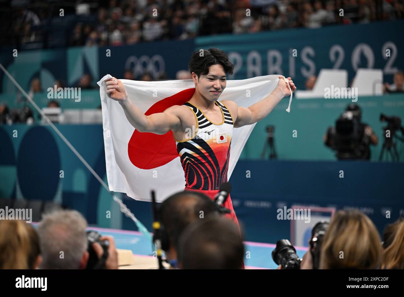 Oka Shinnosuke of Japan with a national flag celebrates after winning ...