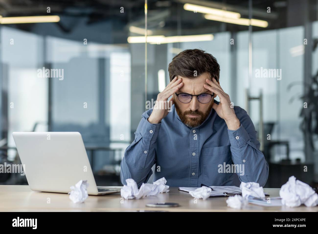 Businessman experiencing stress and frustration at modern office desk ...