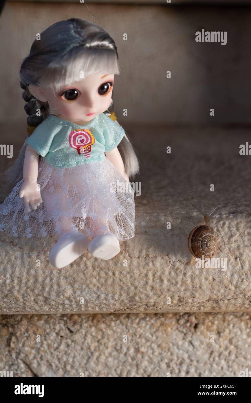 Child's Play: Snail Climbing Stairs with Doll Stock Photo - Alamy