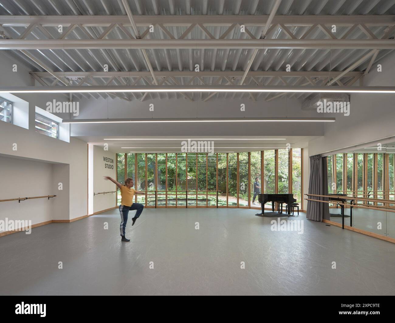 Studio interior with dancer, piano and fenestration. Rambert School of Ballet, London, United ...