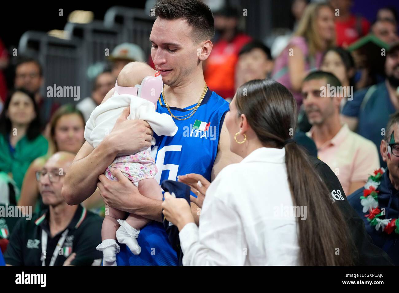 Yuri Romano, of Italy, cries and hugs his newborn child after winning a ...