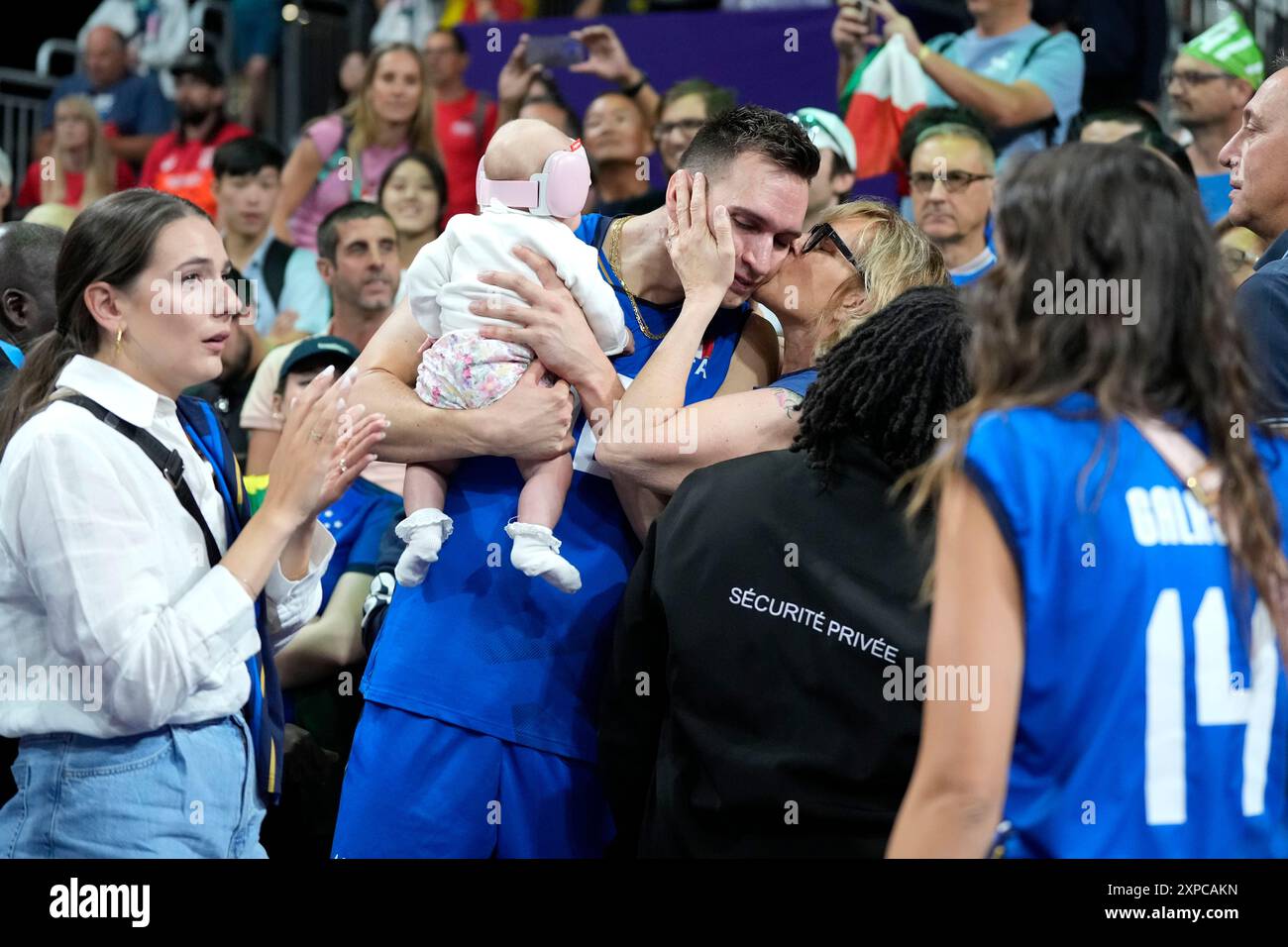 Yuri Romano, of Italy, hugs his family after winning a men's quarter ...