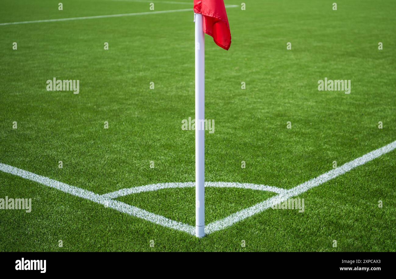 A vibrant green soccer field features a corner flag standing tall ...