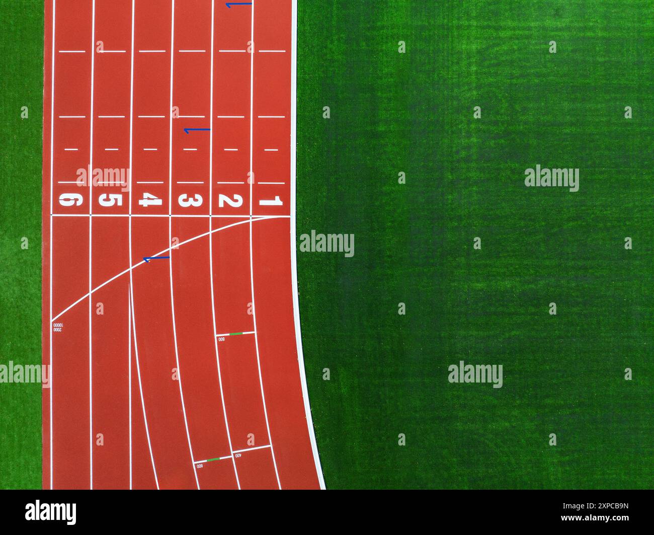 An overhead perspective shows a red running track with marked lanes ...
