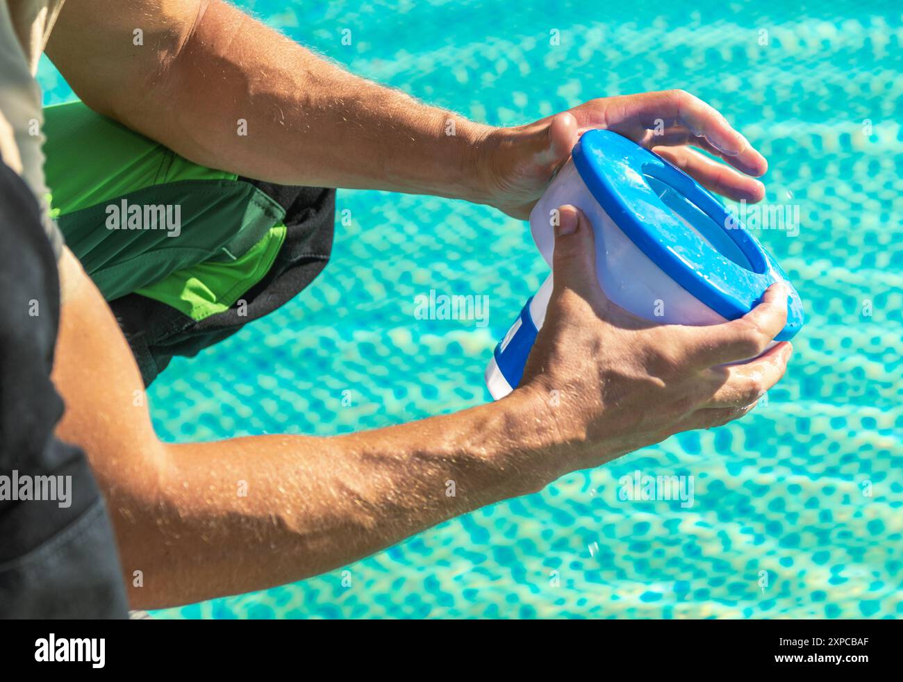 A person uses chlorine pool floater inside his backyard swimming pool ...
