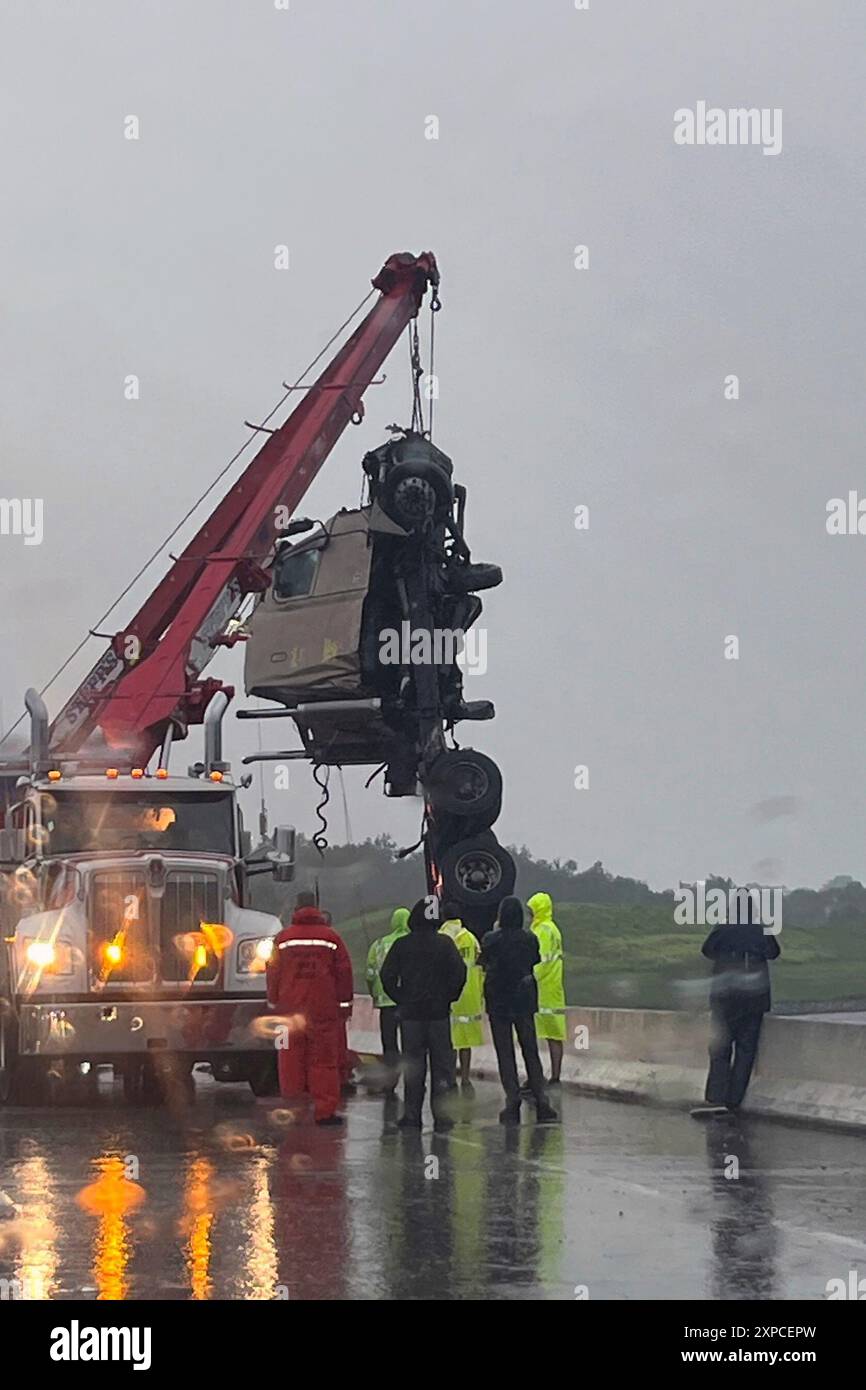 The cab of a tractor trailer is raised from a bridge on Interstate 75 ...