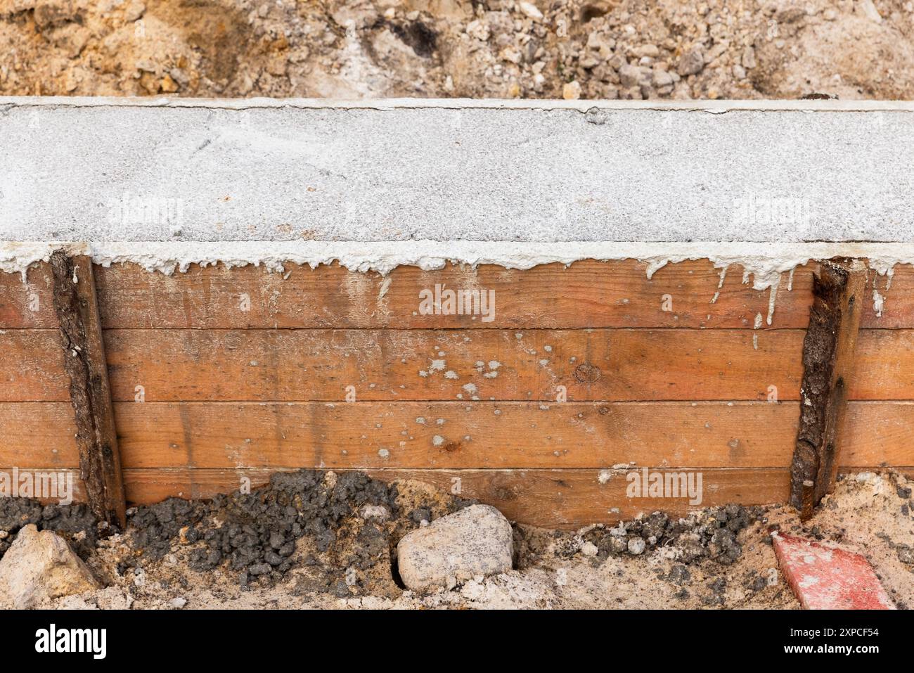 Freshly laid concrete, wall of foundation in wooden formwork. Rural ...