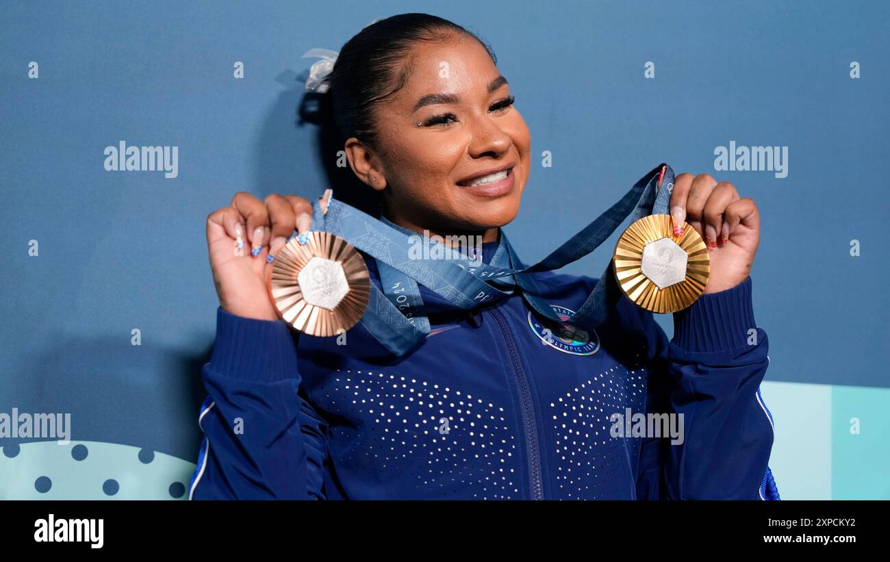 Jordan Chiles, of the United States, holds up her medals after the ...