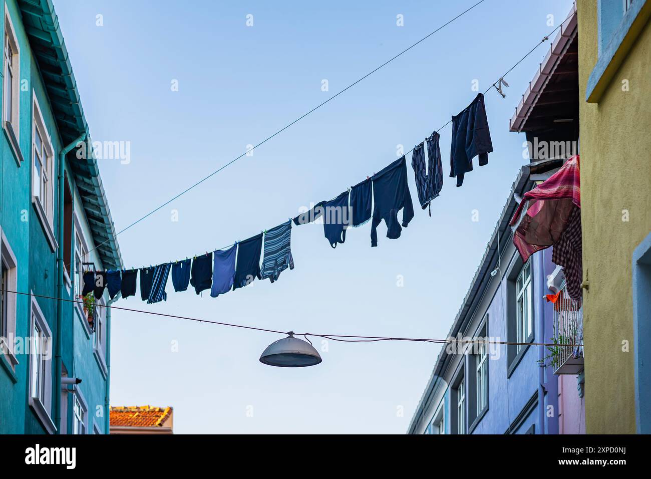 Laundry hanging on a clothesline between colorful buildings under clear ...