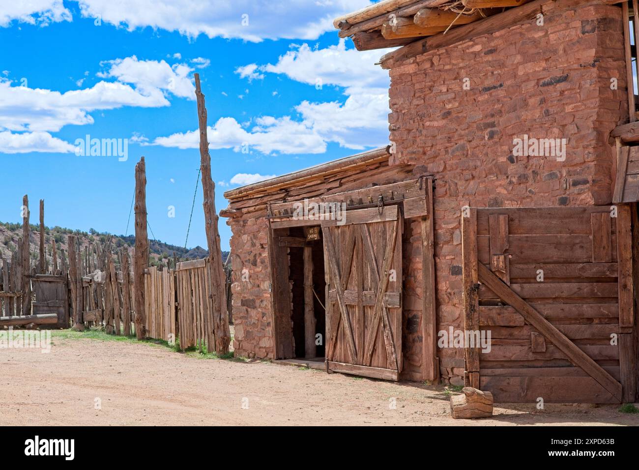 Old stone barn, rustic paddock fence at historic Hubbell Trading Post ...