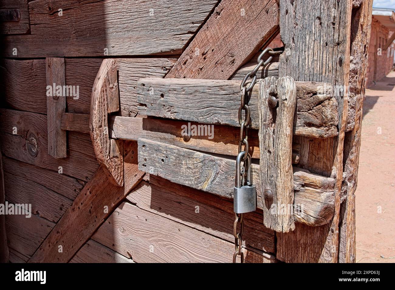 Close up padlock and chain on rustic wooden barn door barrel bolt latch ...