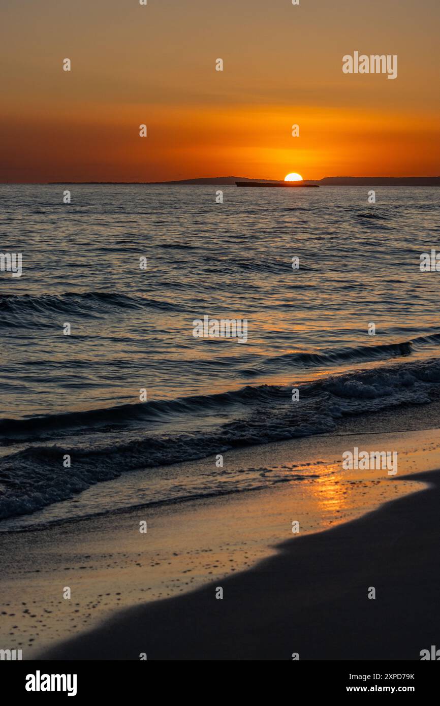 Puesta de sol en la playa de Son Bou, un horizonte dorado con el sol ...