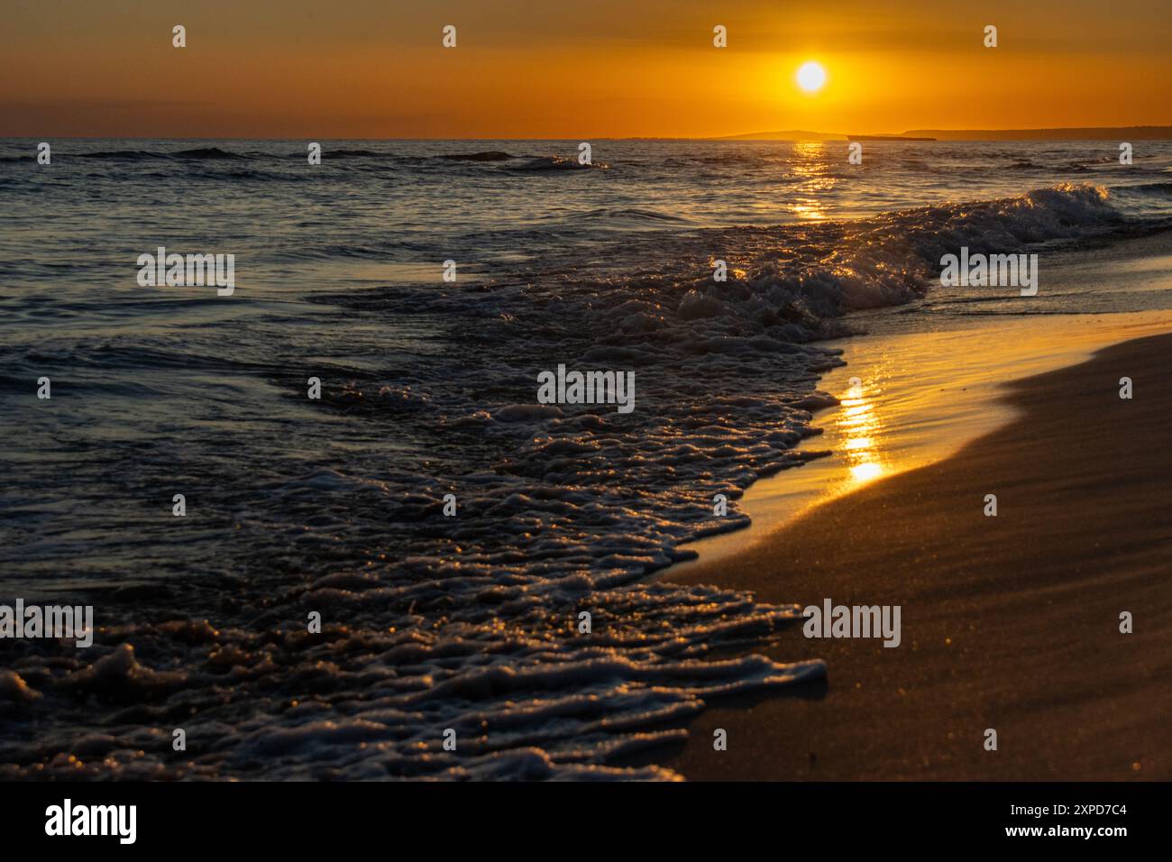 Puesta de sol en la playa de Son Bou, un horizonte dorado con el sol ...