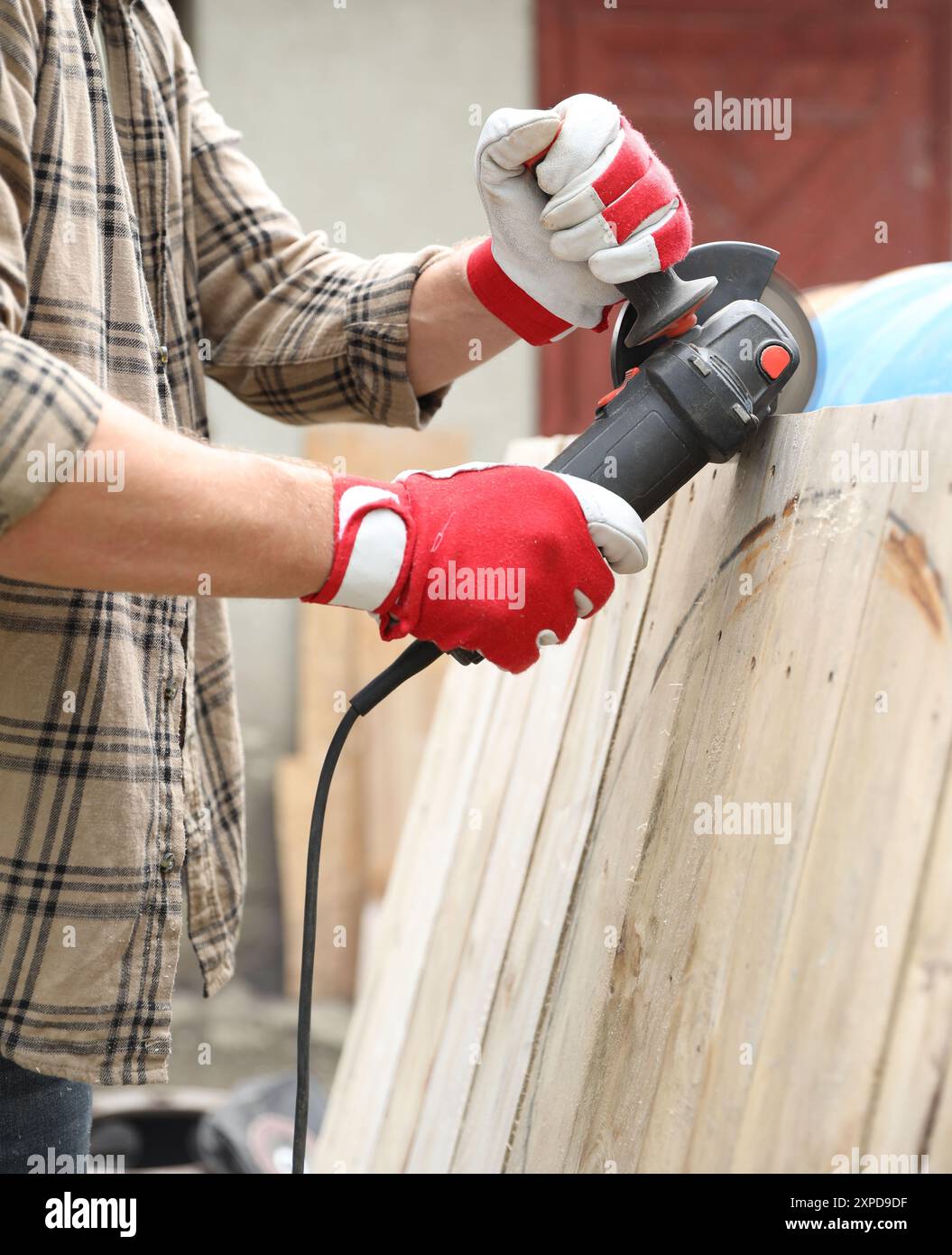 Man grinding wooden planks with angle grinder outdoors Stock Photo - Alamy