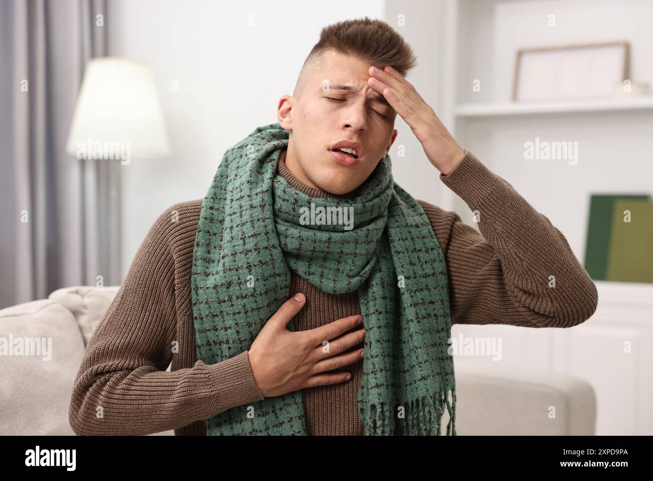 Cold symptom. Young man suffering from fever at home Stock Photo - Alamy