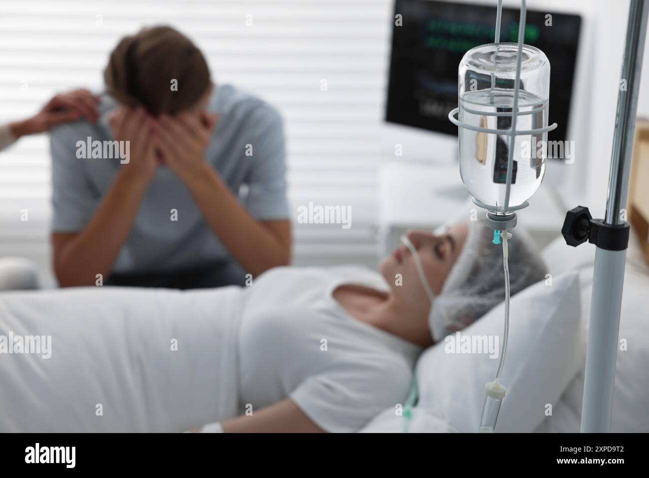 Coma patient. Sad man near his unconscious wife in hospital, selective ...