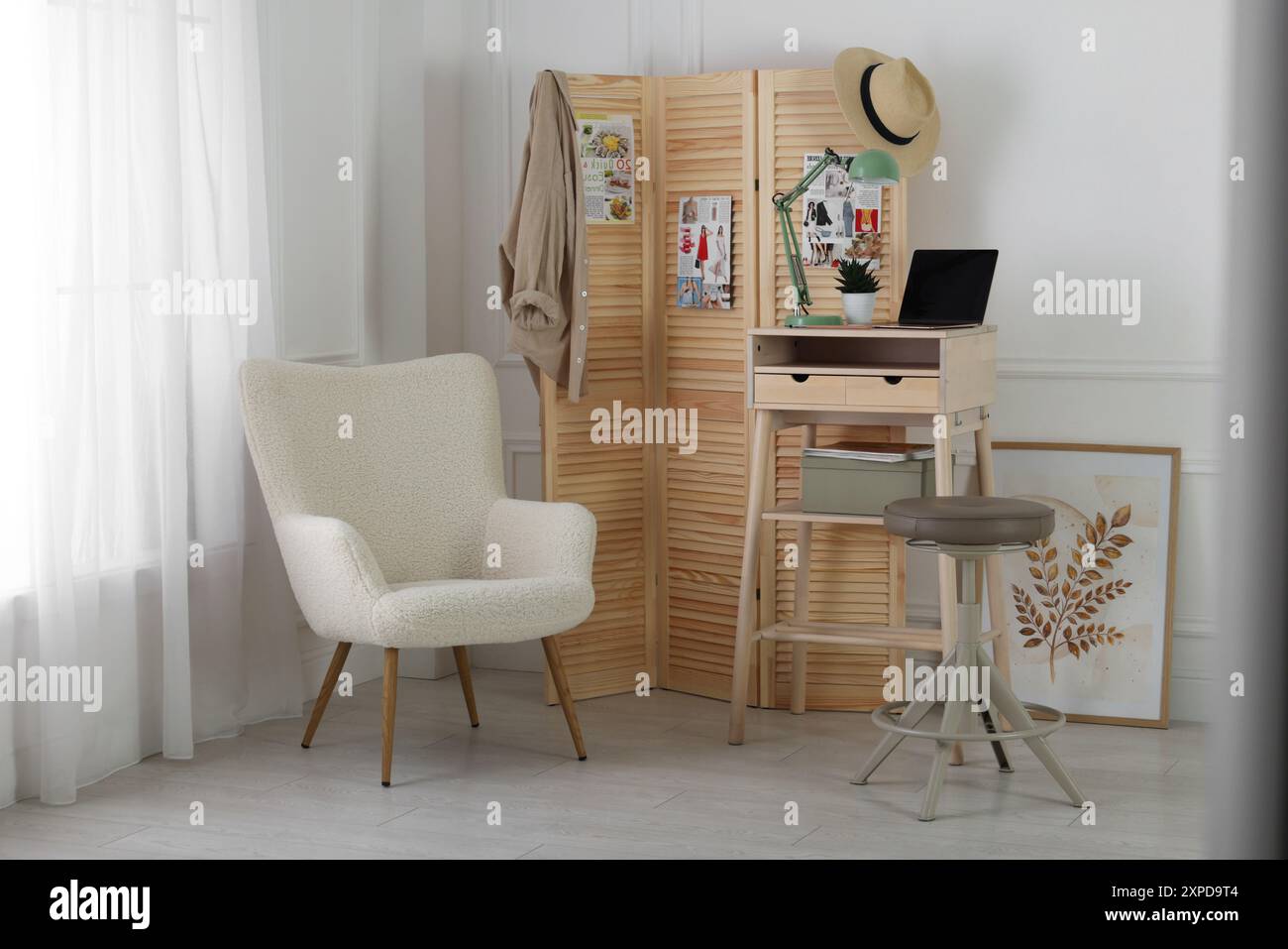 Folding screen, table, laptop, lamp and armchair indoors. Interior ...
