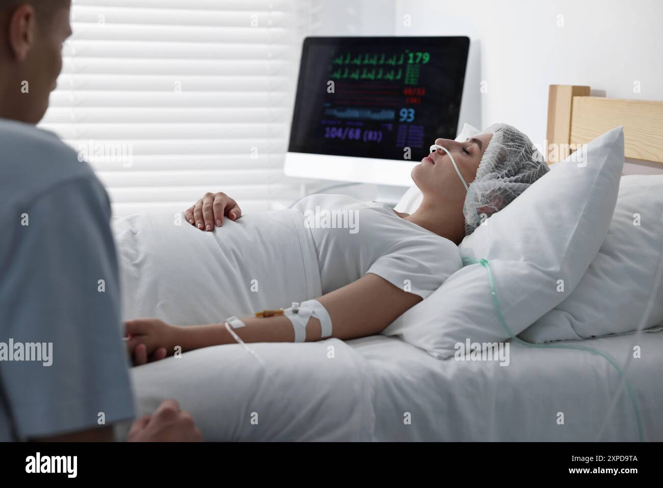 Coma patient. Sad young man near his unconscious wife in hospital Stock ...