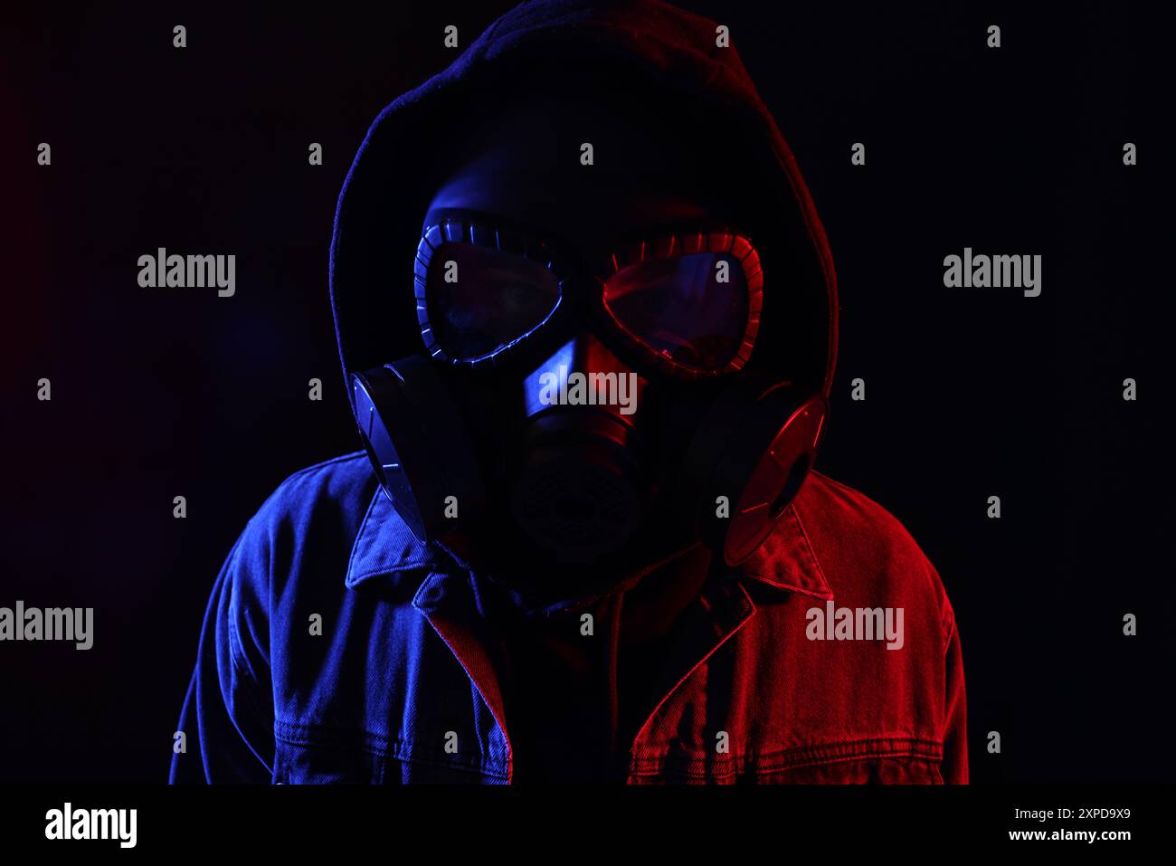 Man wearing gas mask in color lights on black background Stock Photo ...