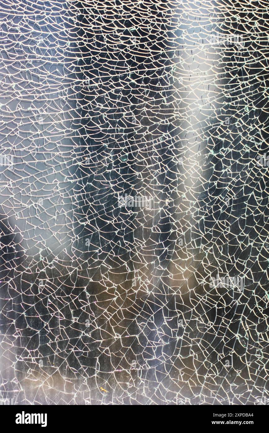 A detailed view of a shattered glass window, showing intricate patterns ...
