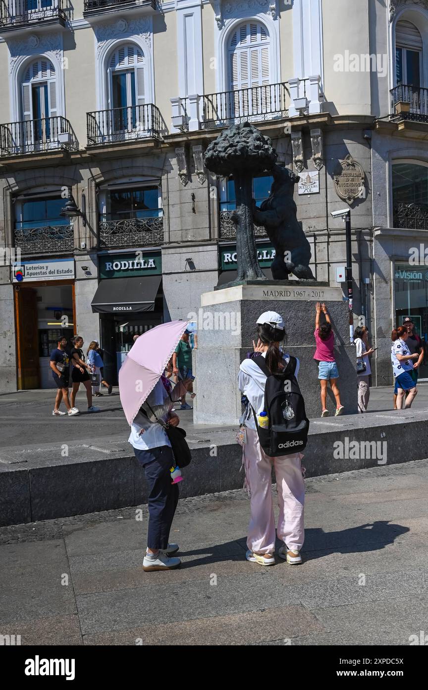 Two female tourists one holding a pink parasol against the afternoon ...