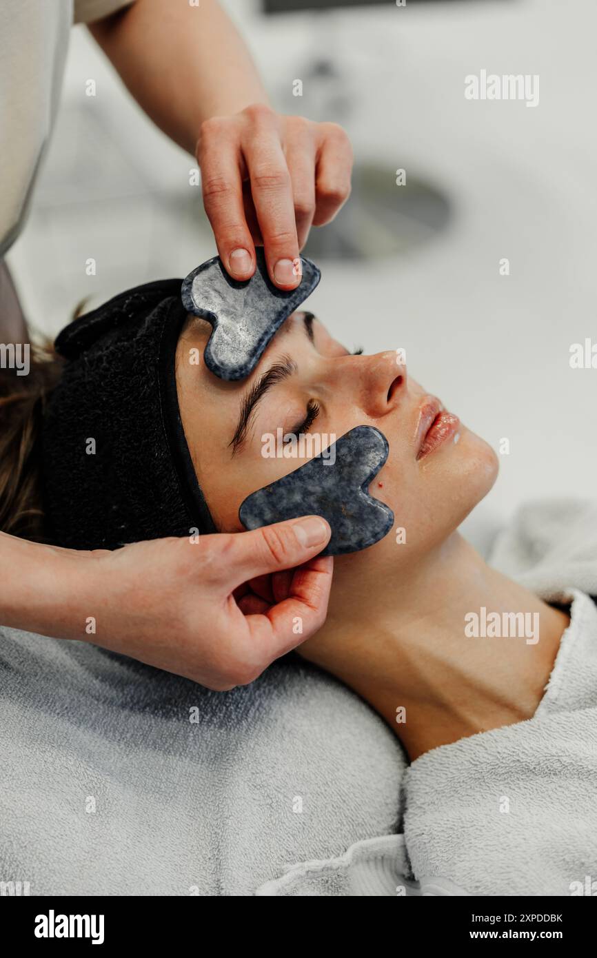 Relaxing facial treatment at spa featuring gua sha technique in ...