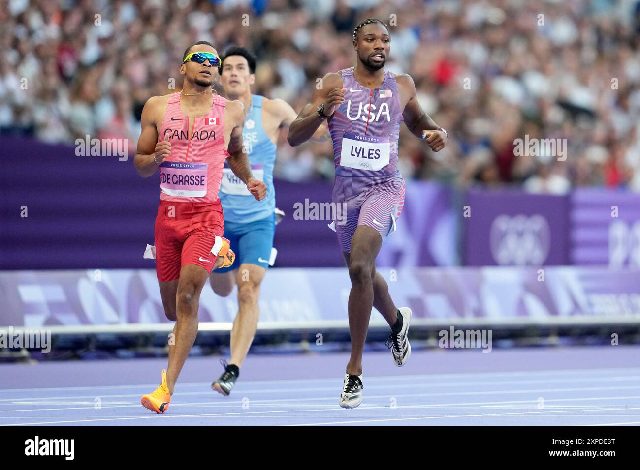 Noah Lyles, of the United States, and Andre de Grasse, of Canada, cross ...