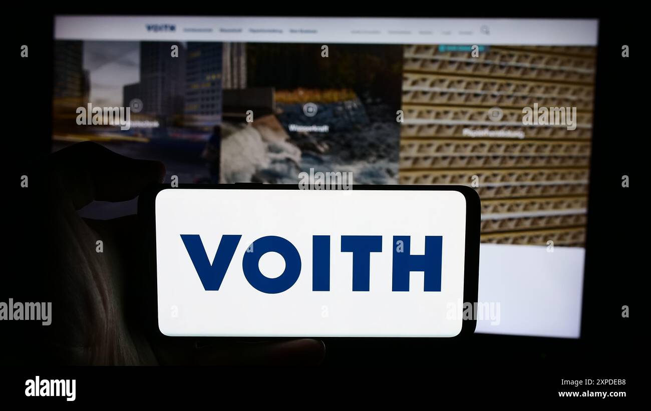 Person holding cellphone with logo of German technology company Voith ...