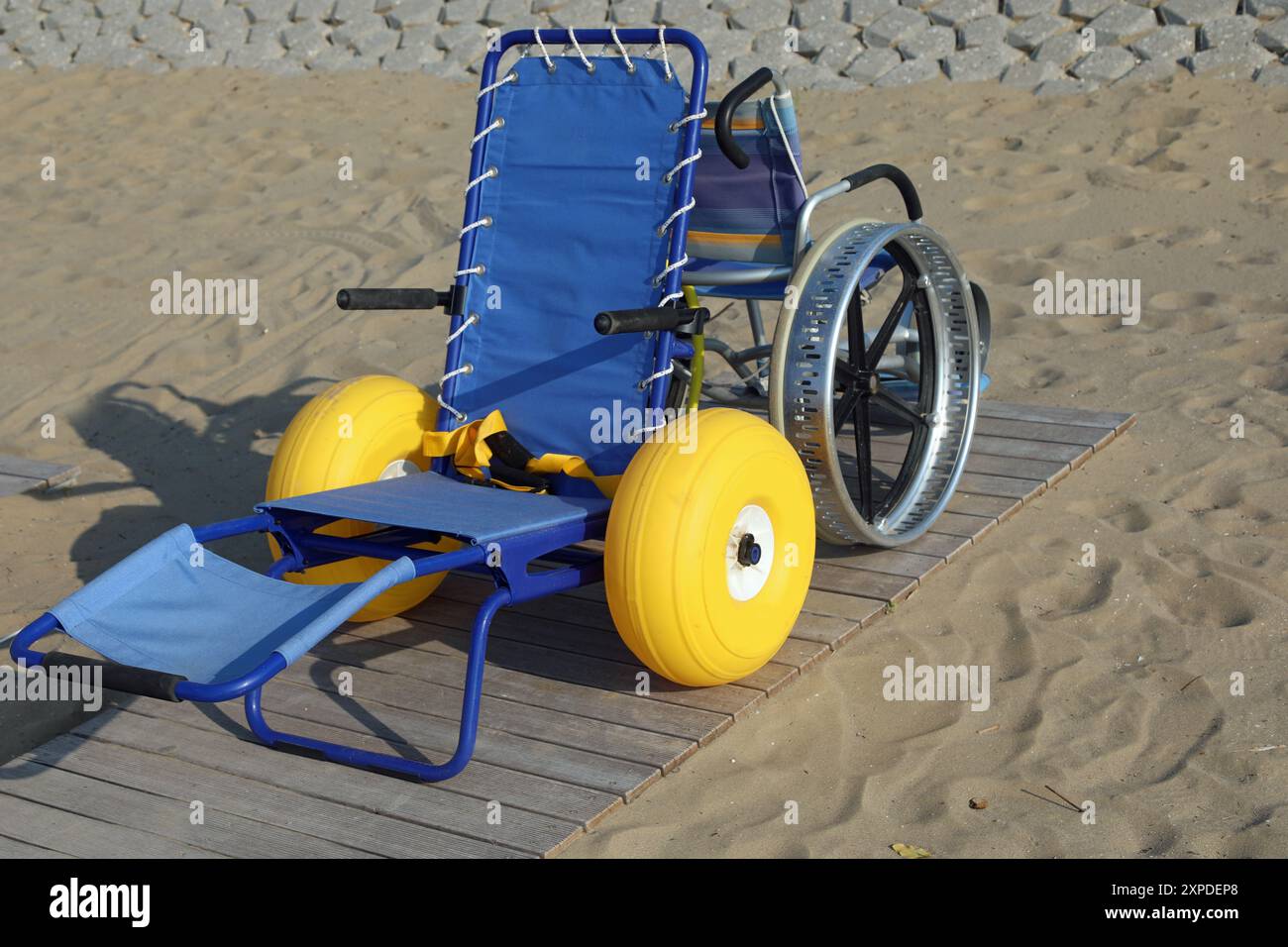 Special beach wheelchair going into the water with large yellow ...