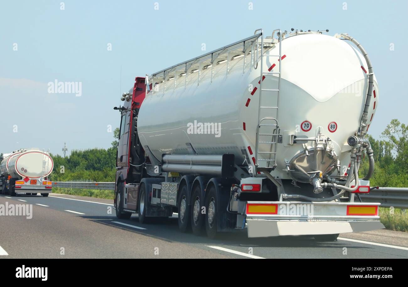 Large white fuel tanker truck carrying flammable fuel on a highway ...