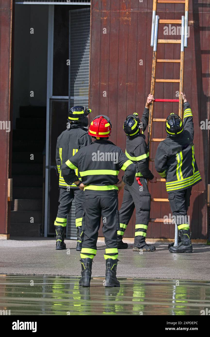 fire chief commands the team firefighters who assemble the ladder to ...