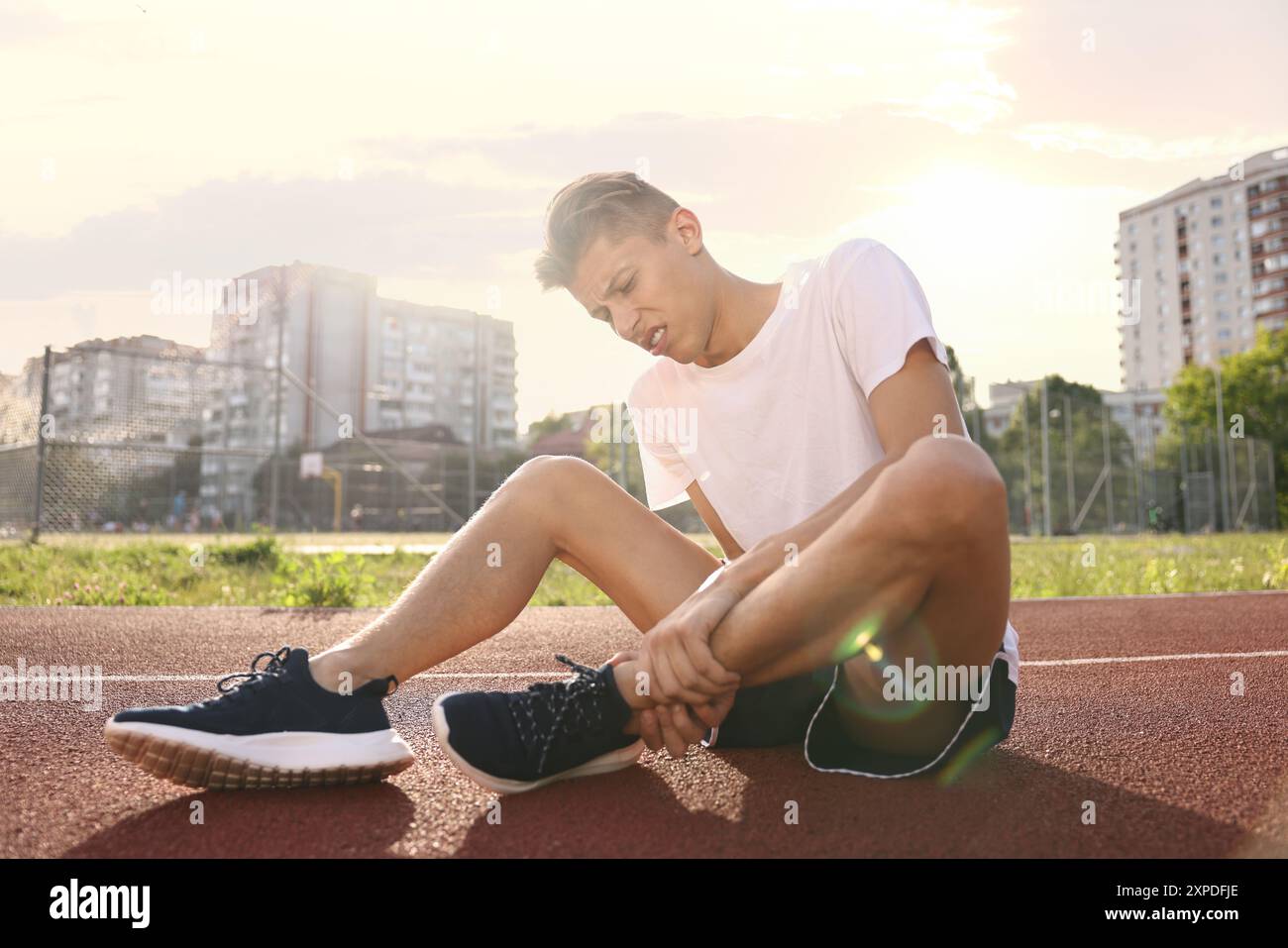 Sports injury. Man suffering from leg pain at stadium Stock Photo - Alamy