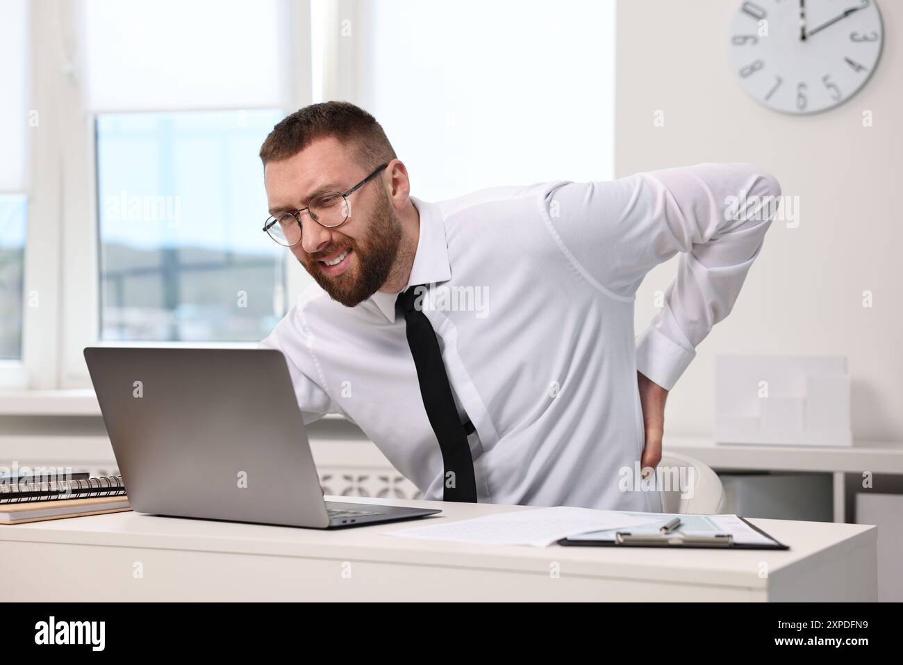 Man suffering from back pain in office. Symptom of poor posture Stock ...