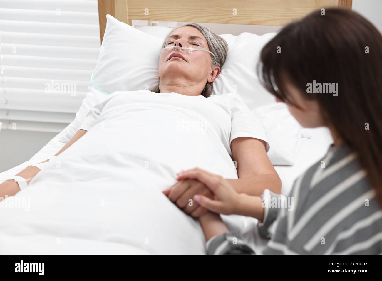 Coma patient. Woman near her unconscious mother in hospital Stock Photo ...