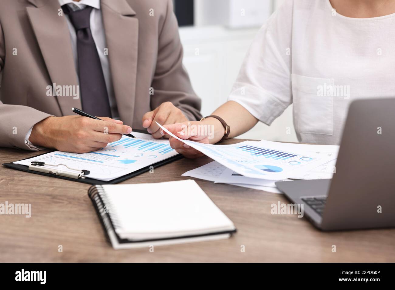 Consultant working with client at wooden table in office, closeup ...