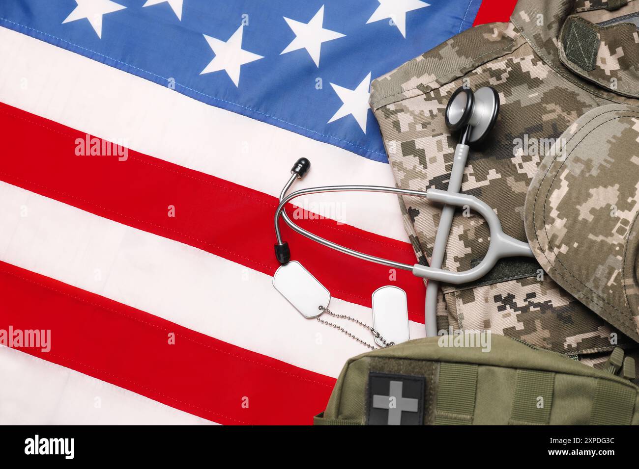 Stethoscope, first aid kit, tags and military uniform on USA flag, top ...