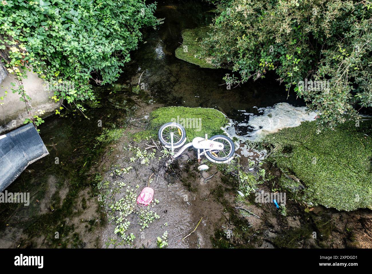 Rubbish including a discarded bicycle rests in a stream in Dublin ...
