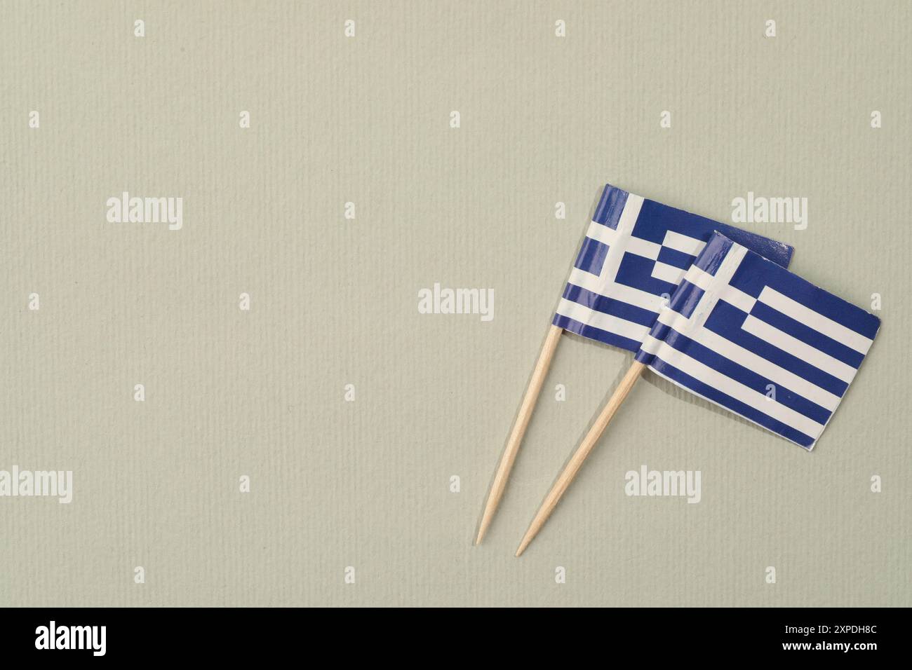 Small paper flags of Greece on light background, top view. Space for ...