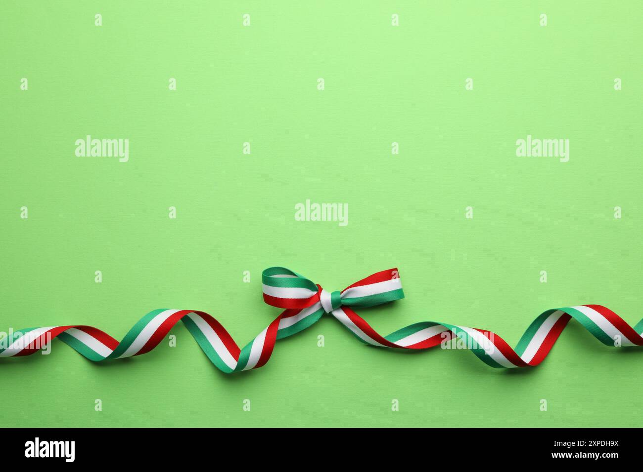 Ribbon with bow in colors of Hungarian flag on green background, top ...