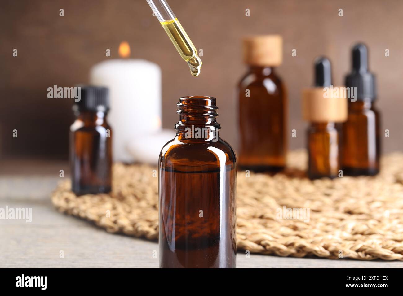 Essential oil dripping from pipette into bottle at table, closeup Stock ...