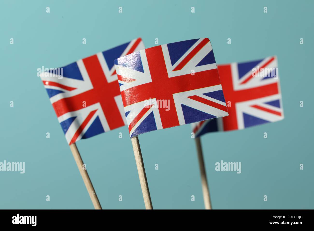 Small paper flags of United Kingdom on light blue background, selective ...