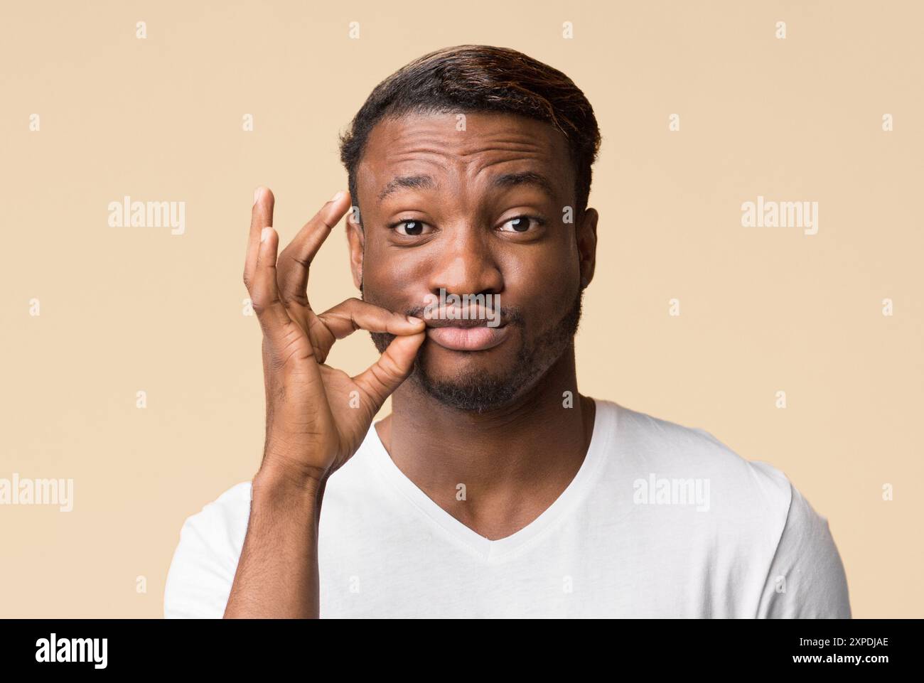 Afro Man Making Zip Lip Gesture Standing, Studio Shot Stock Photo - Alamy